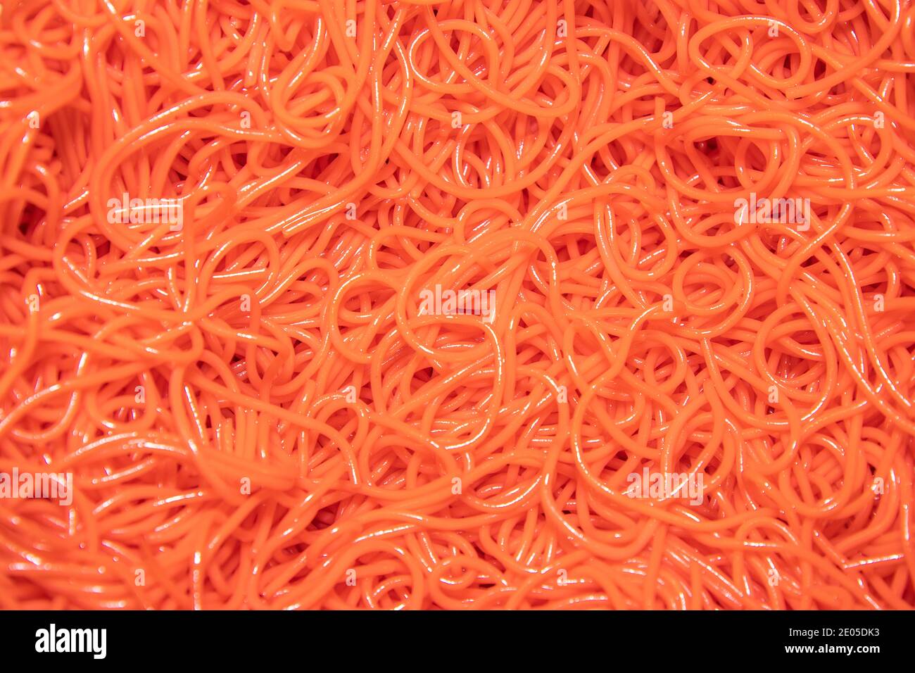 A close up of spaghetti mixed with red food colouring to be used as a ...