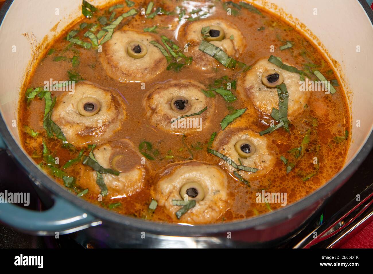 A spooky stew made up of dumplings with olives to male it look like eye ...