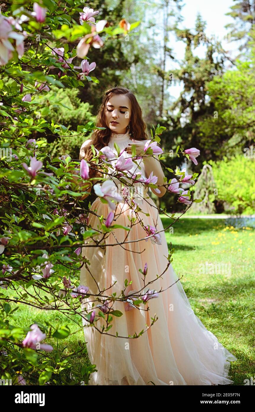 Portrait of young attractive woman in spring garden with blooming ...