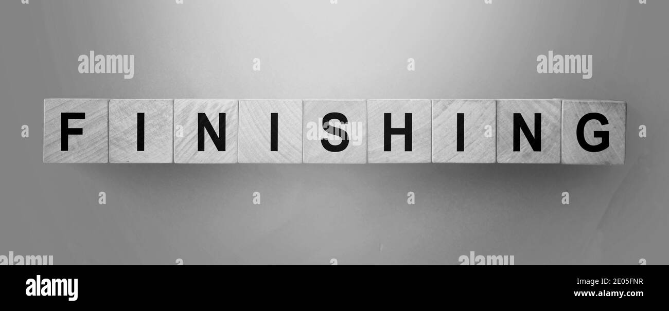 Finishing word on a wood blocks and blue background. Final business ...