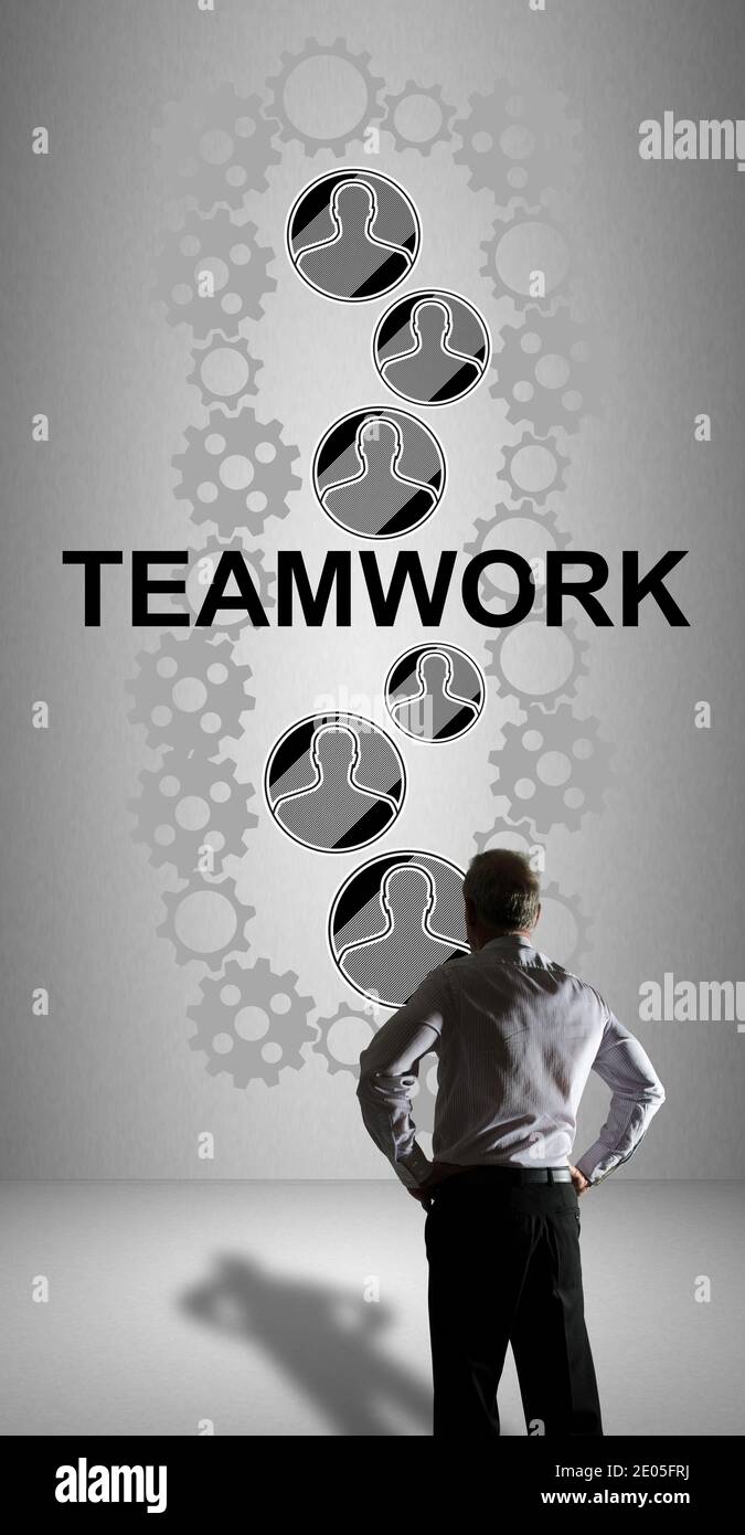 Businessman watching a teamwork concept drawn on a wall Stock Photo - Alamy