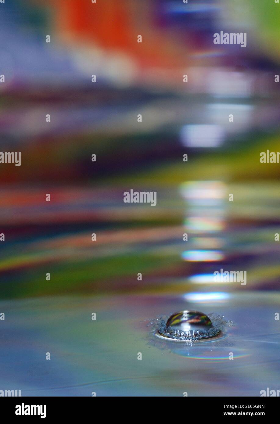 drop impacting in colorful liquid and dripping with crown Stock Photo ...