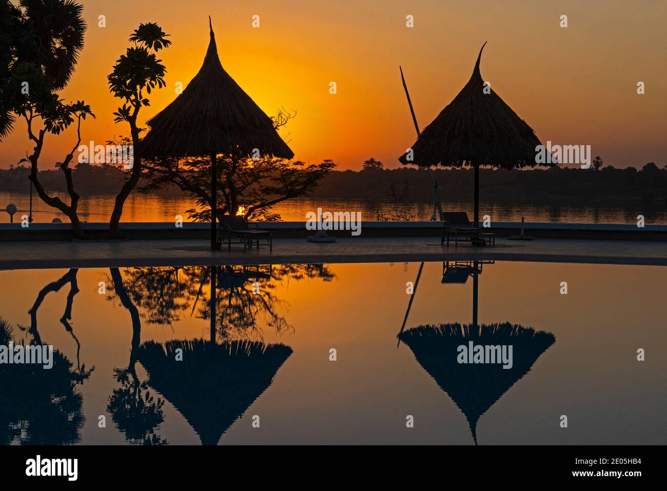 Outdoor swimming pool in a tropical luxury hotel resort at evening ...