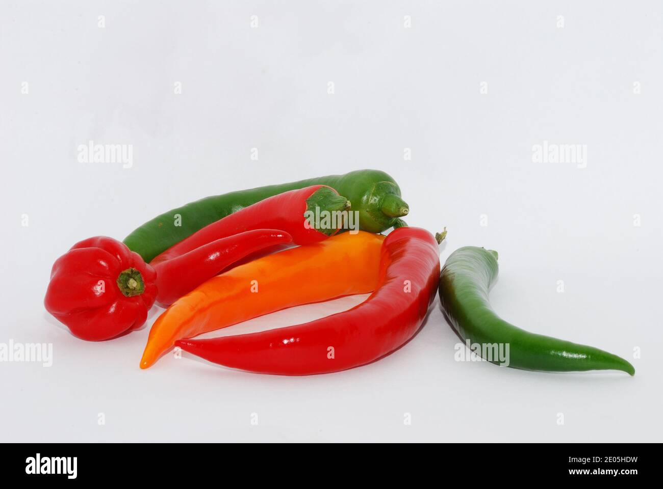 different colored hot chili on white background Stock Photo - Alamy
