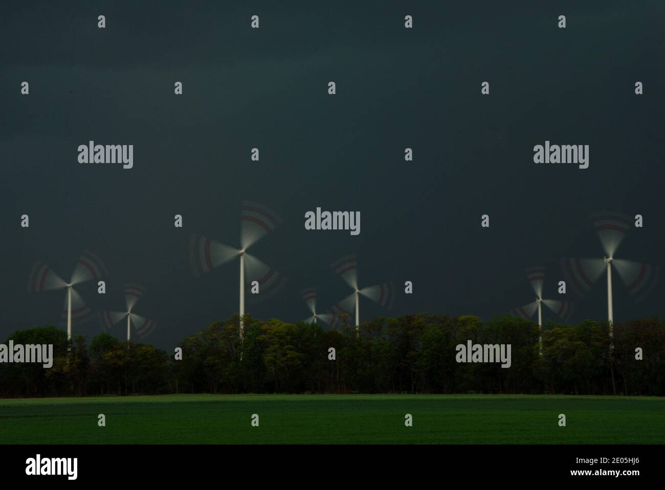 many large wind wheel rotate very rapidly among black sky and ...