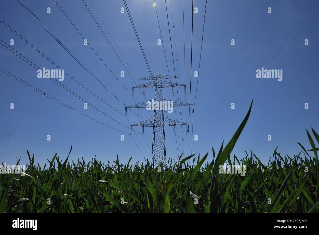 green energy with field and grass in the foreground and electricity ...