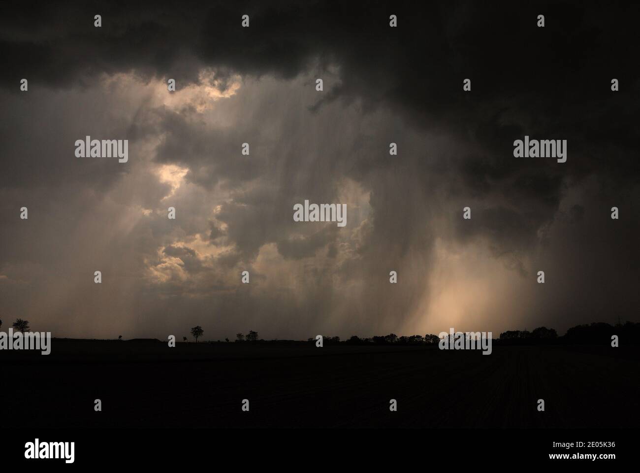 big black storm clouds and rain shower with the sun in summer Stock ...