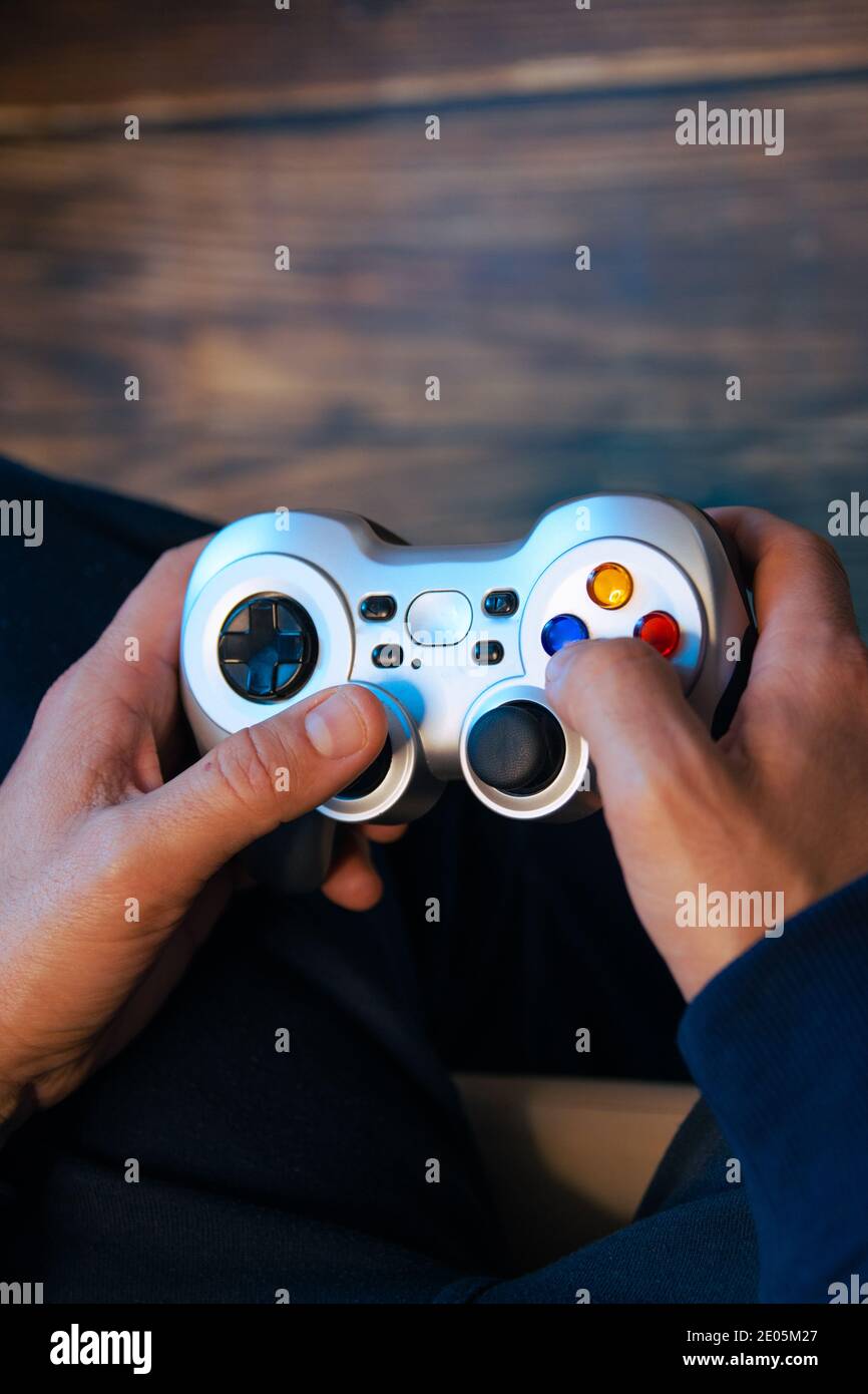 Close-up of a man's hands holding a video game controller with a screen ...