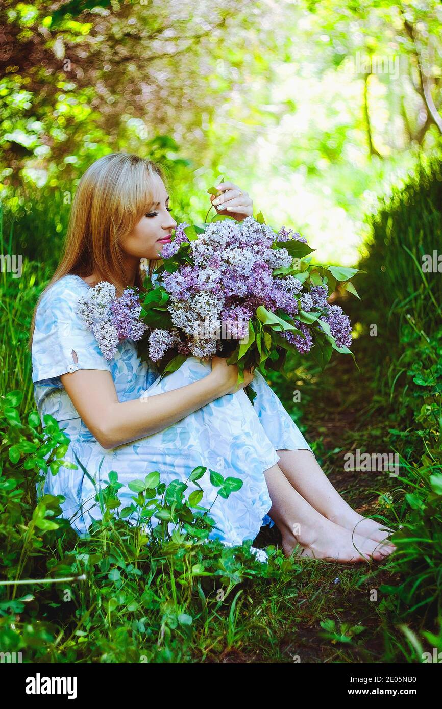 Portrait of young attractive woman in spring garden with a bouquet of ...