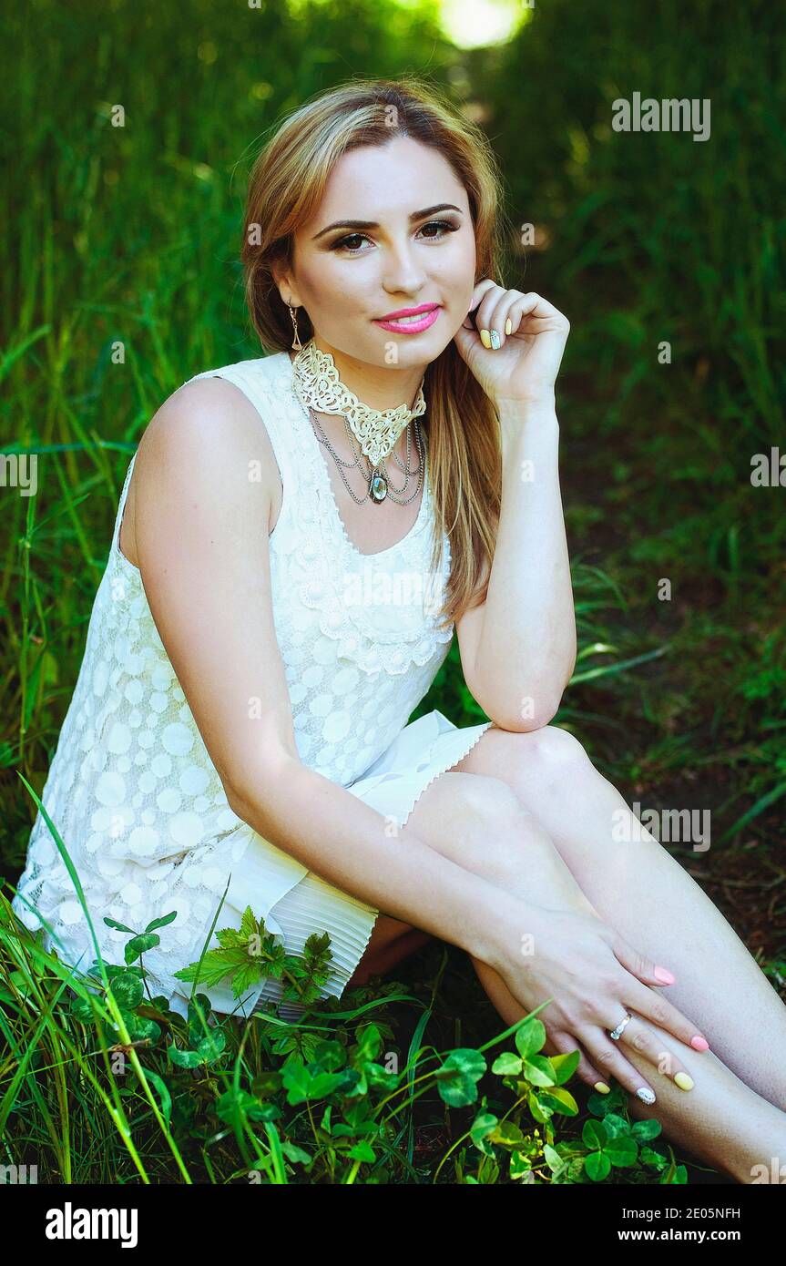 Portrait of young attractive woman in white clothes with a beautiful ...