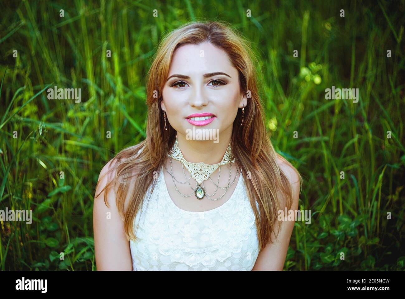 Portrait of young attractive woman in white clothes with a beautiful ...