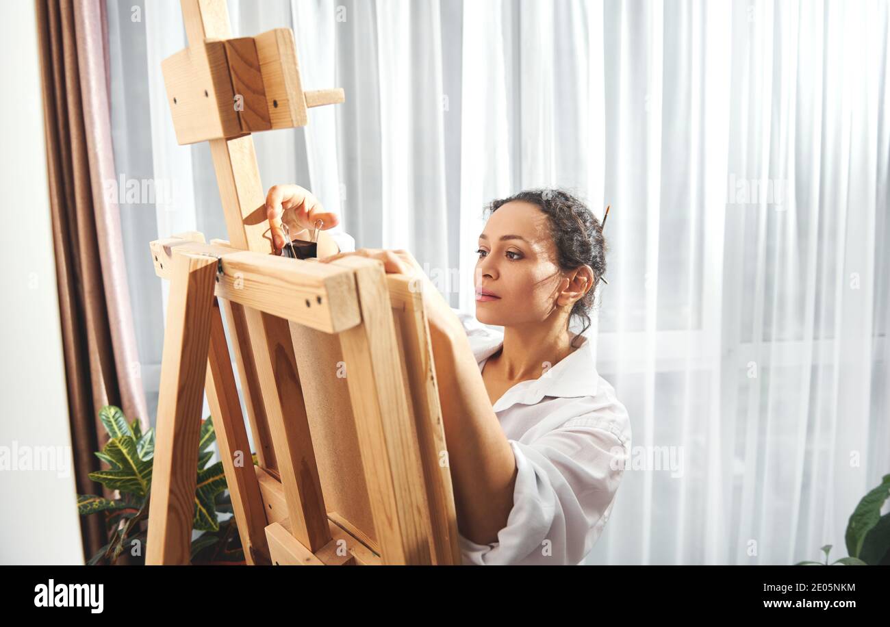 Top view of a beautiful brunette painter with gathered hair in a bun ...