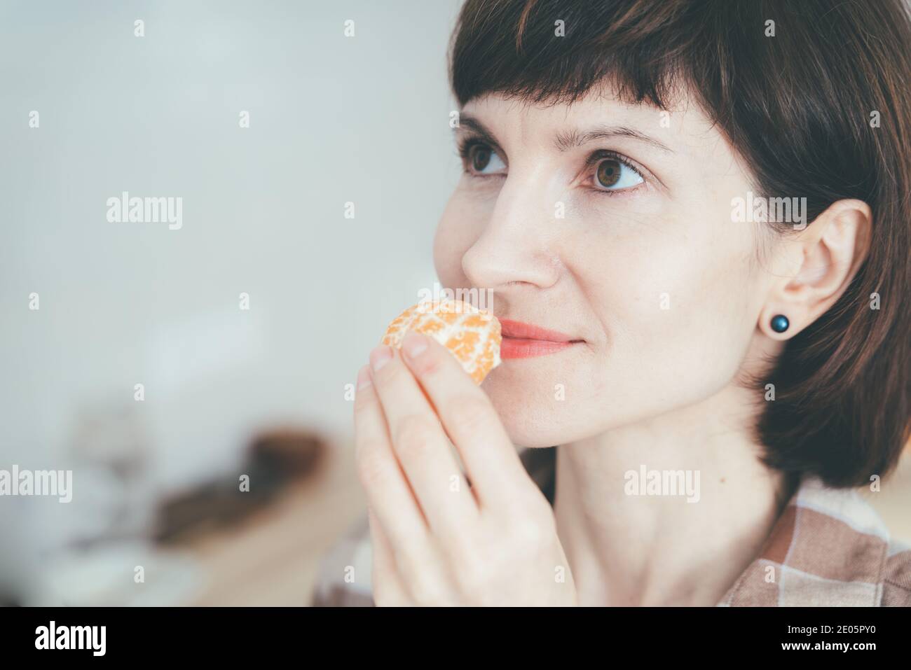 Close up happy woman sniffing citrus fruit and smelling aroma tangerine ...