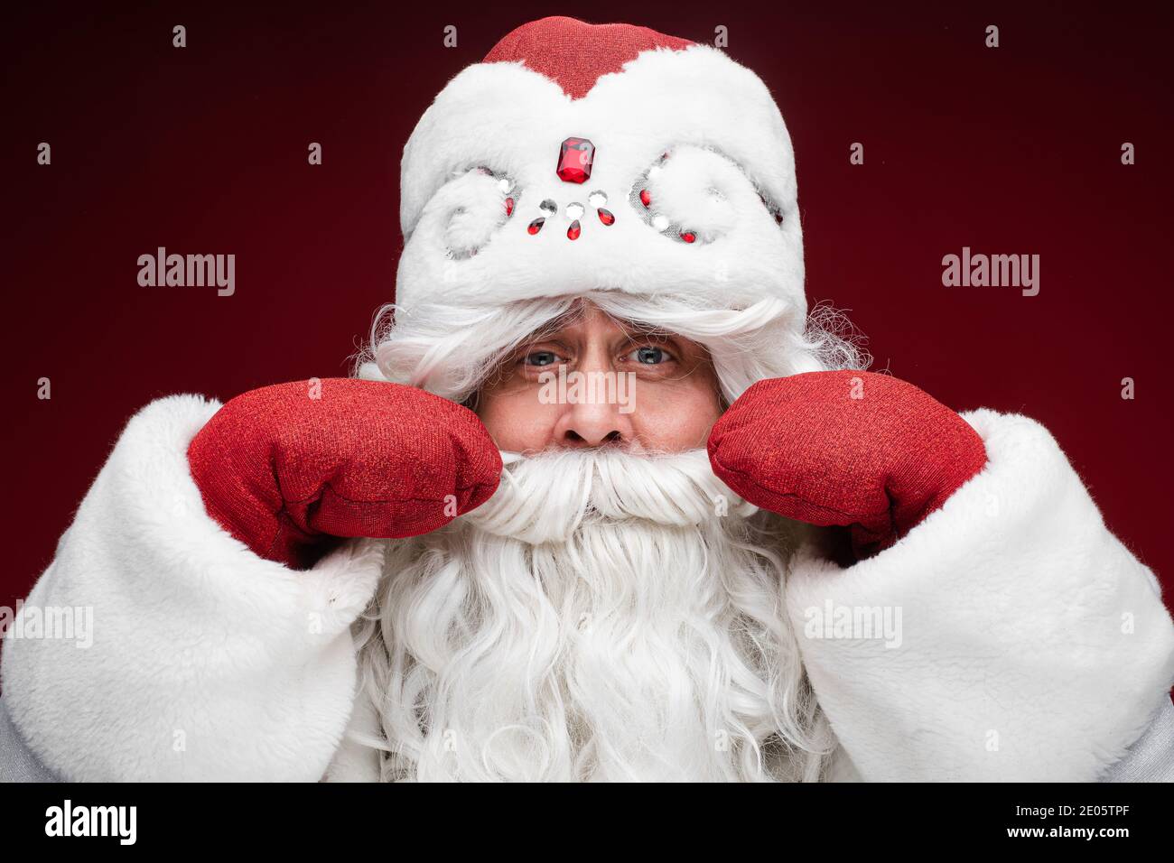 Santa gray haired senior male in mittens show his mustache, close up ...