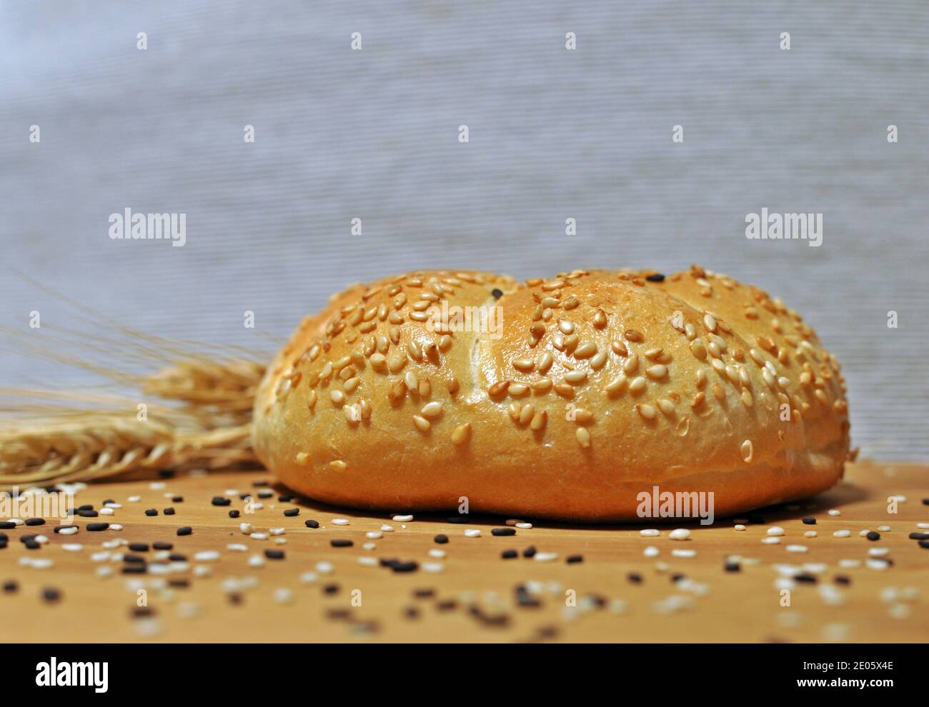 Front view of a fresh backed bun with wheat and sesame ornament on ...