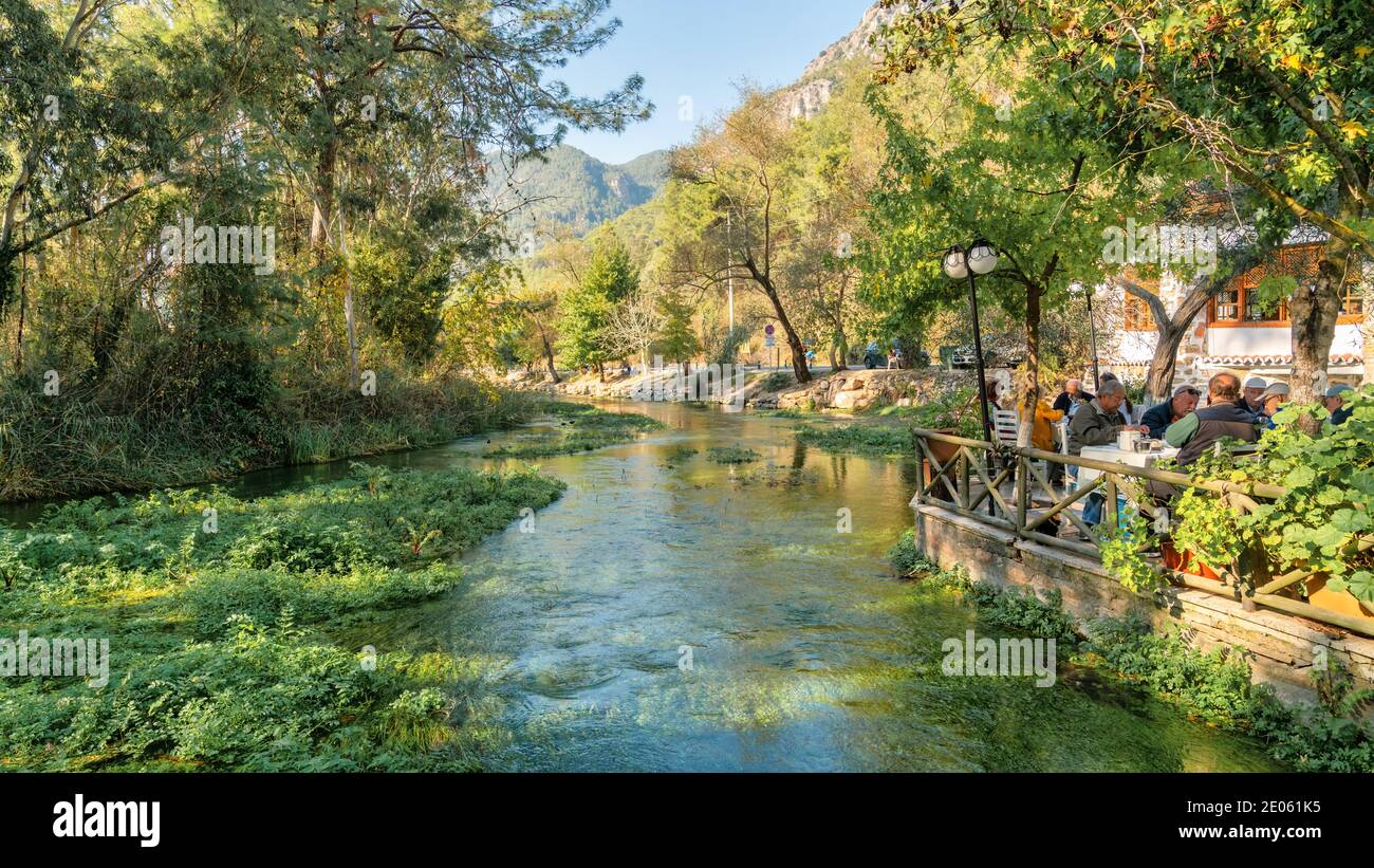 Marmaris, Akyaka, Turkey - November 2020: People eating by the Azmak ...
