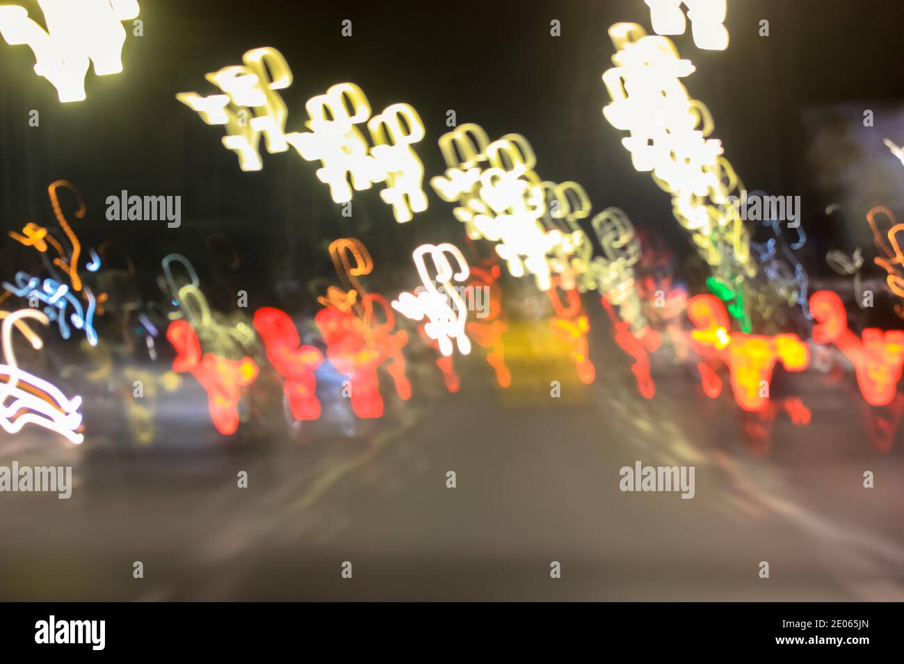 Cars on the road in the city at night and neon lights of headlights and ...