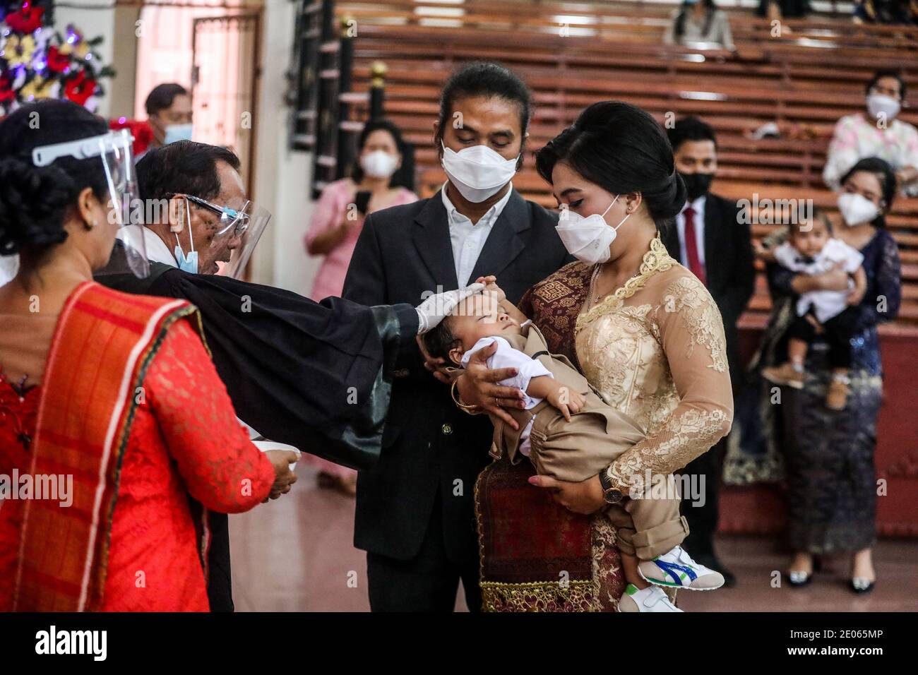 A priest wearing a face shield as a measure against the spread of ...