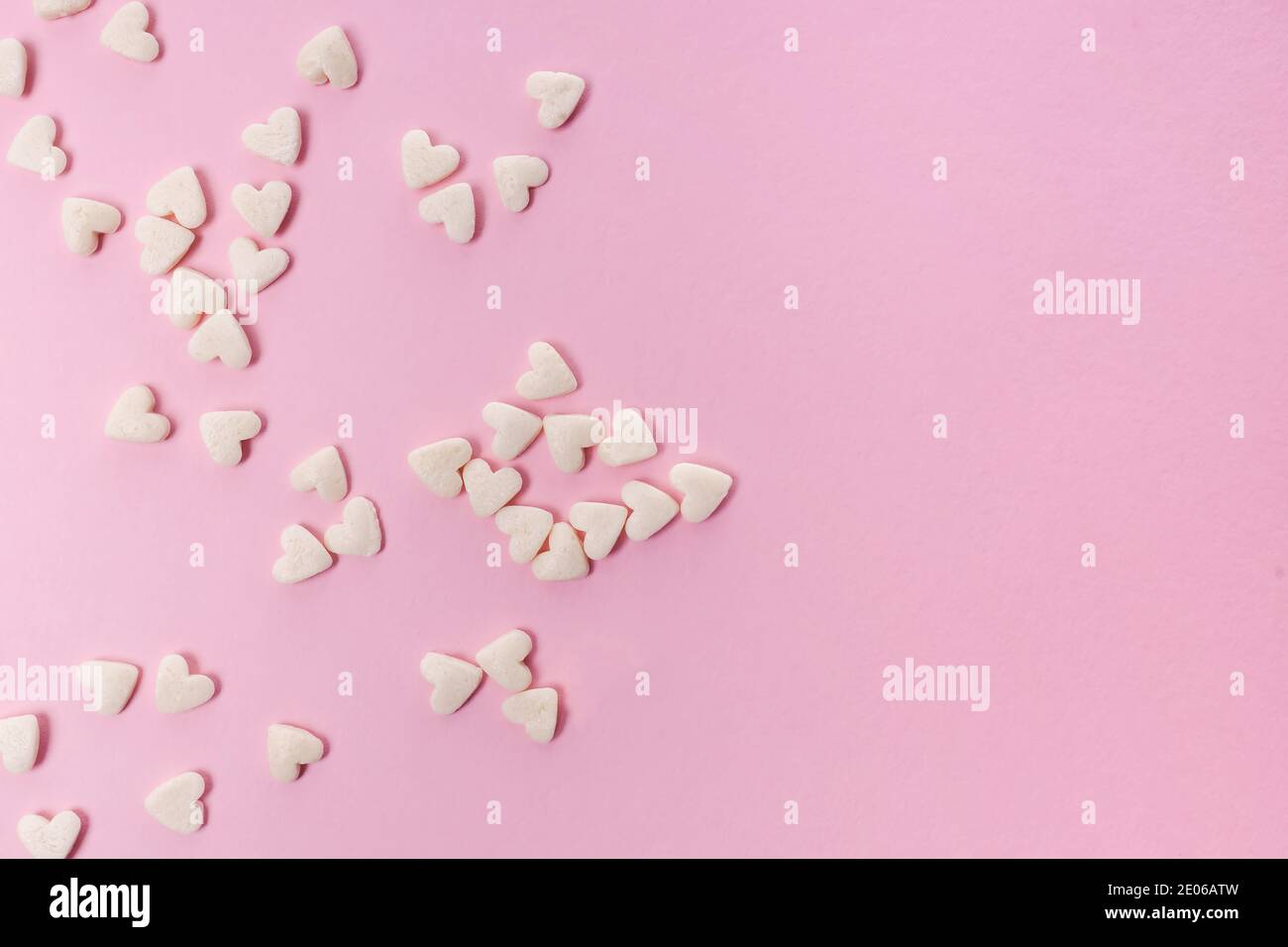 Sugar heart shaped sprinkles on pink background Stock Photo - Alamy