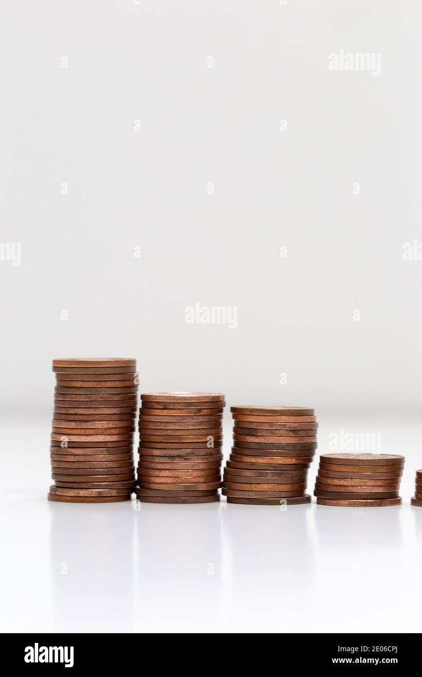 Side view of stacks of coins increasing in height, on white studio ...