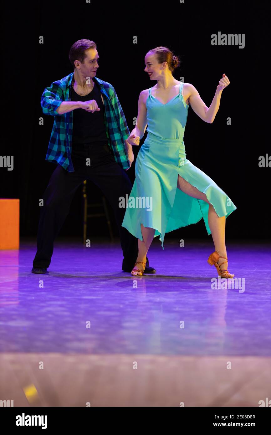 A pair of dancers a man and a woman perform in a theater on stage in a ...