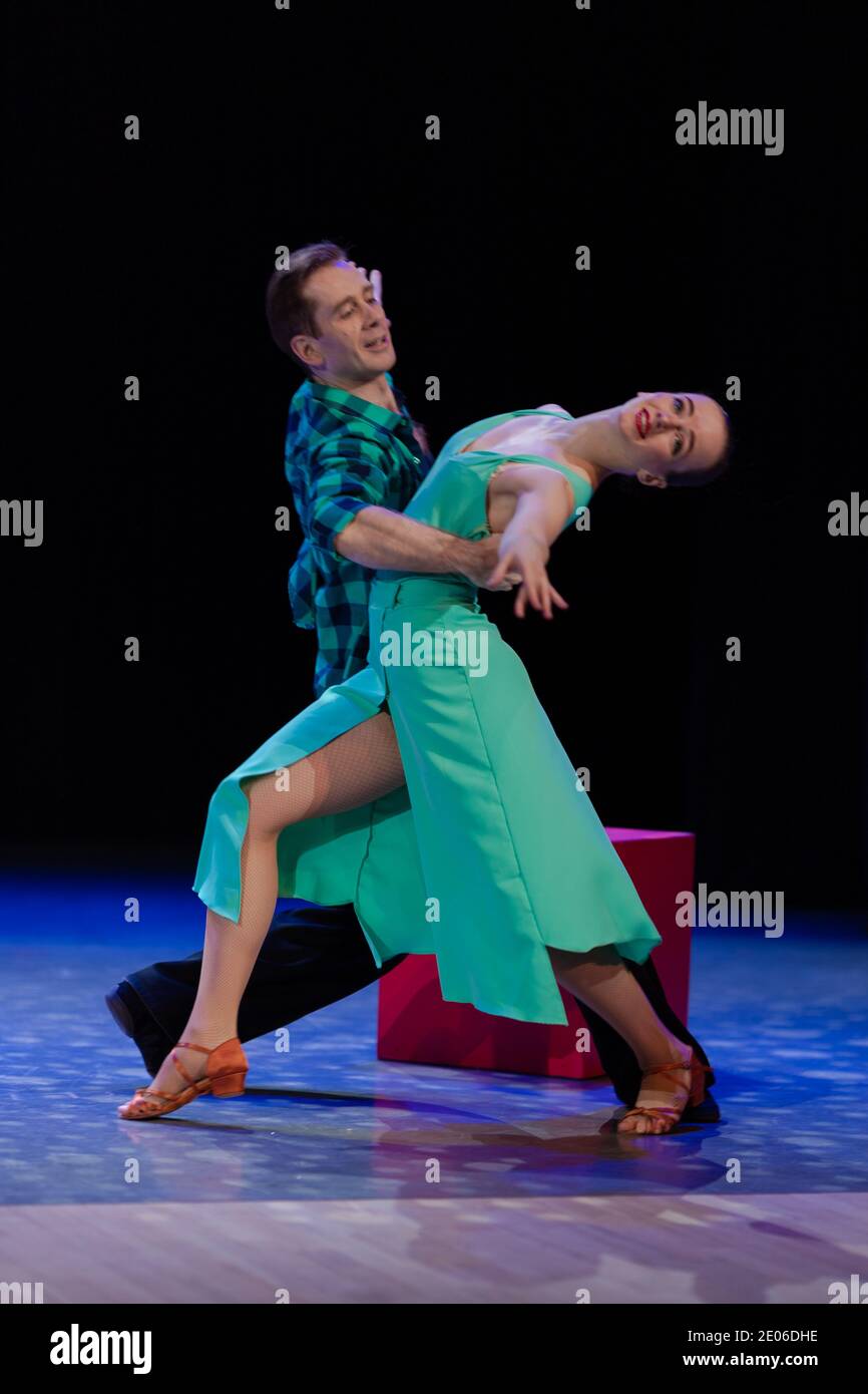 A pair of dancers a man and a woman perform in a theater on stage in a ...