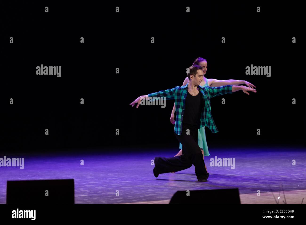 A pair of dancers a man and a woman perform in a theater on stage in a ...