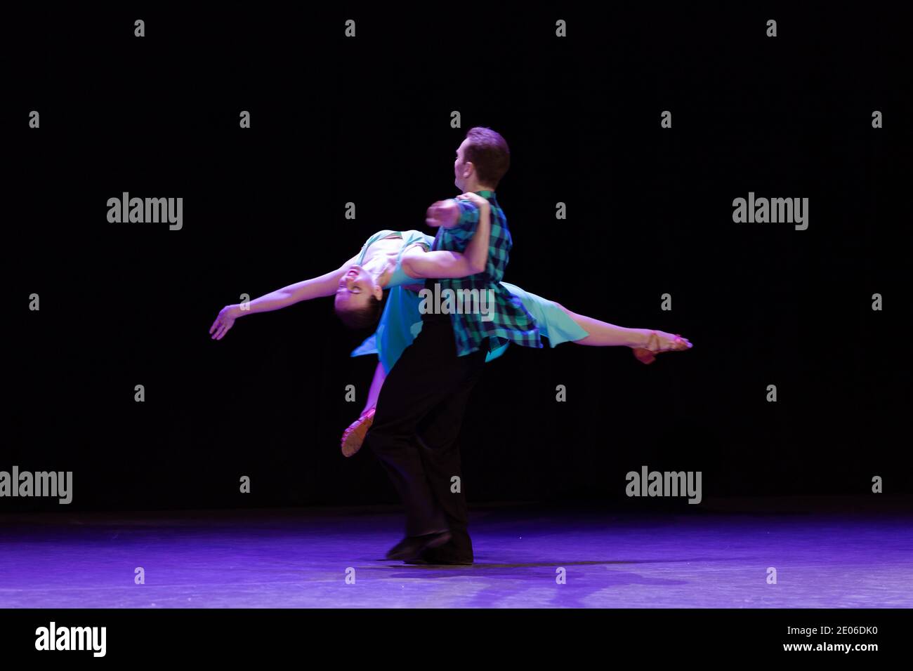 A pair of dancers a man and a woman perform in a theater on stage in a ...