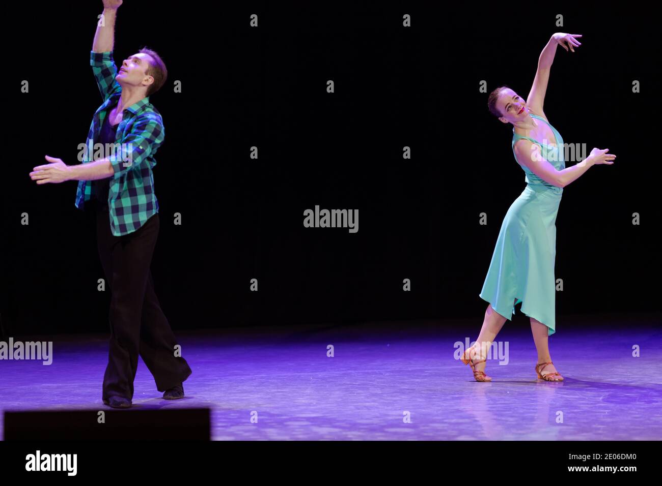 A pair of dancers a man and a woman perform in a theater on stage in a ...