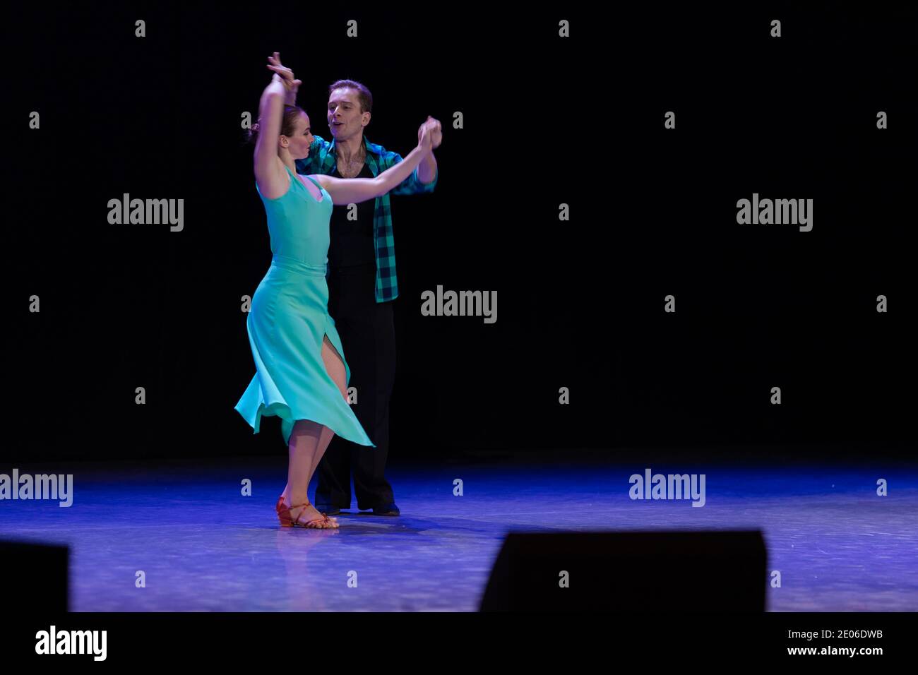 A pair of dancers a man and a woman perform in a theater on stage in a ...