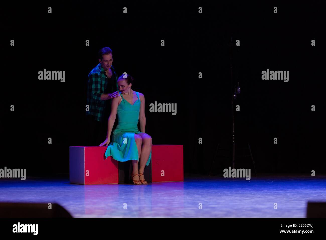 A pair of dancers a man and a woman perform in a theater on stage in a ...