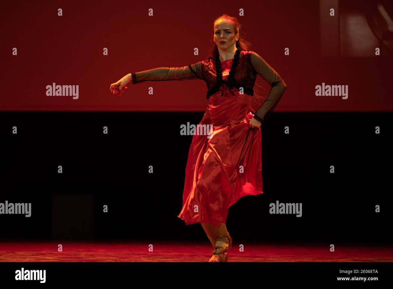 Dancer in a red dress dancing Spanish flamenco on the stage in the ...