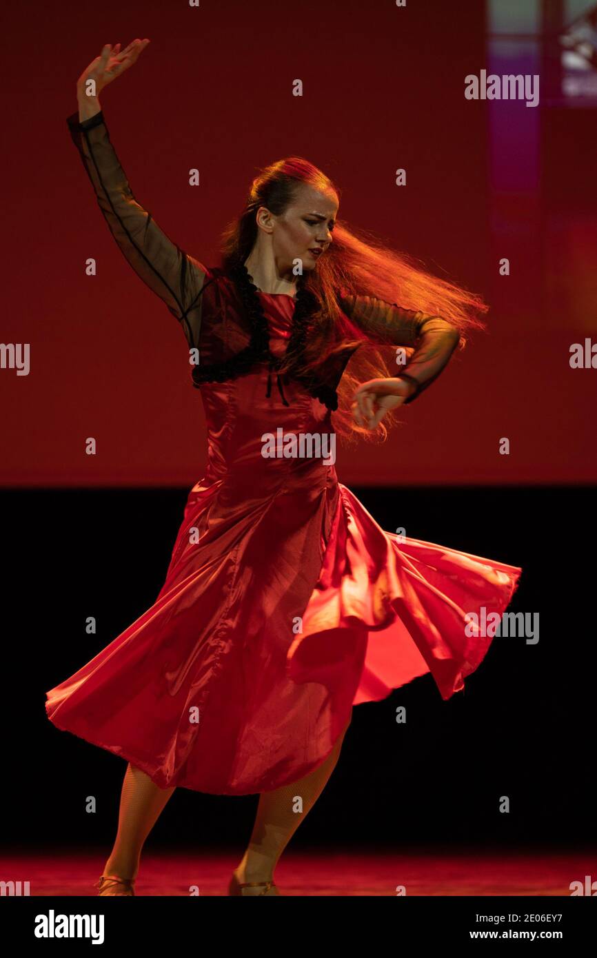 Dancer in a red dress dancing Spanish flamenco on the stage in the ...