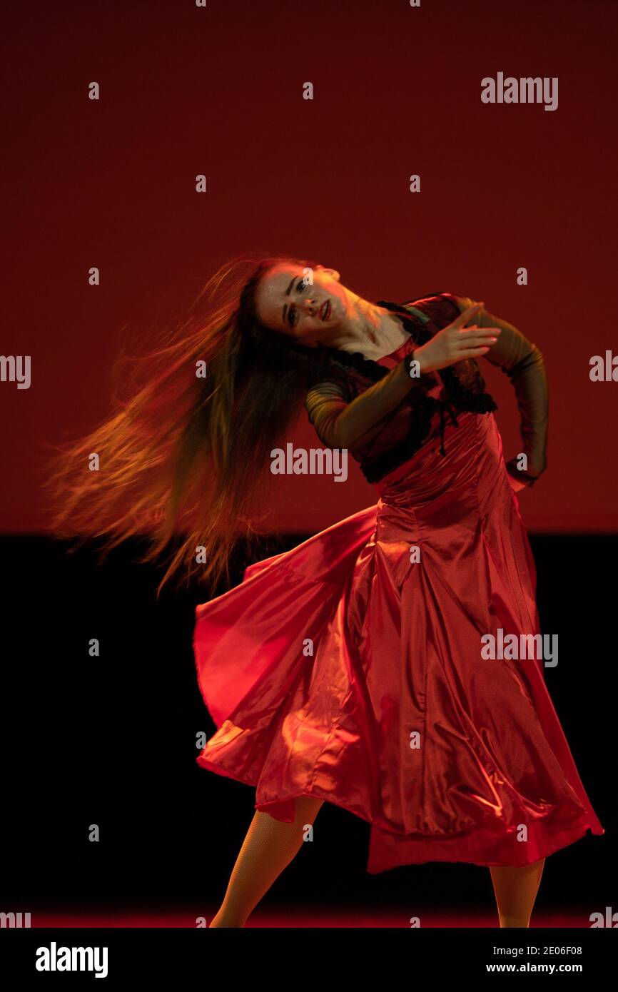 Dancer in a red dress dancing Spanish flamenco on the stage in the ...