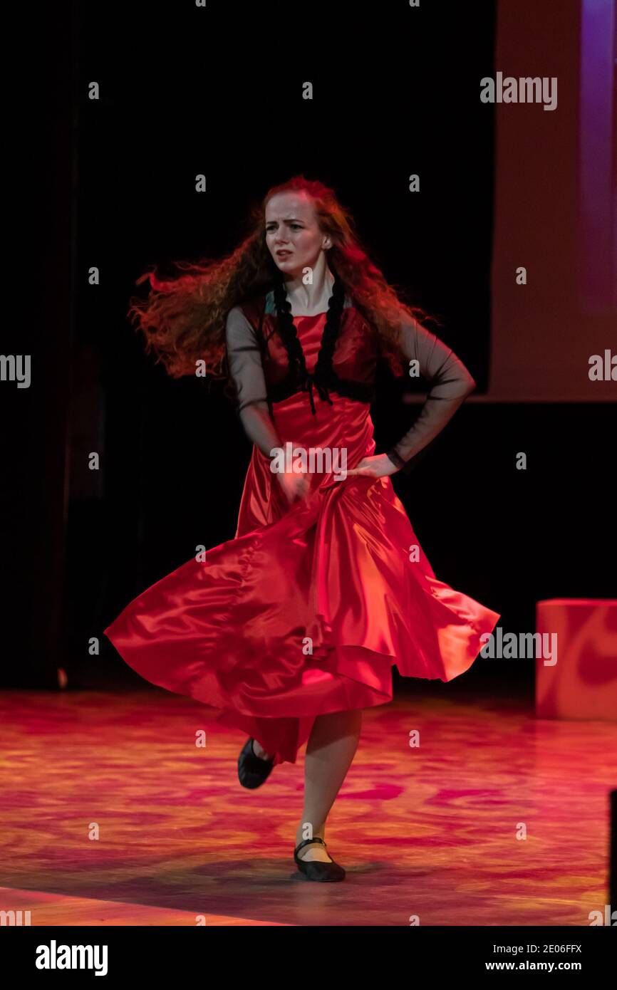 Dancer in a red dress dancing Spanish flamenco on the stage in the ...