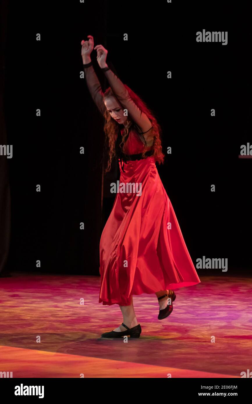 Dancer in a red dress dancing Spanish flamenco on the stage in the ...