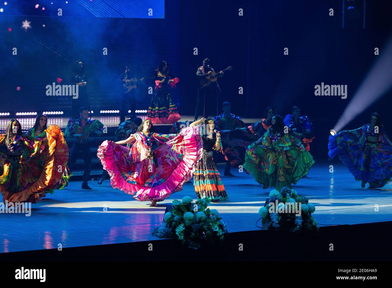 A team of musicians and singers perform on stage in front of the ...