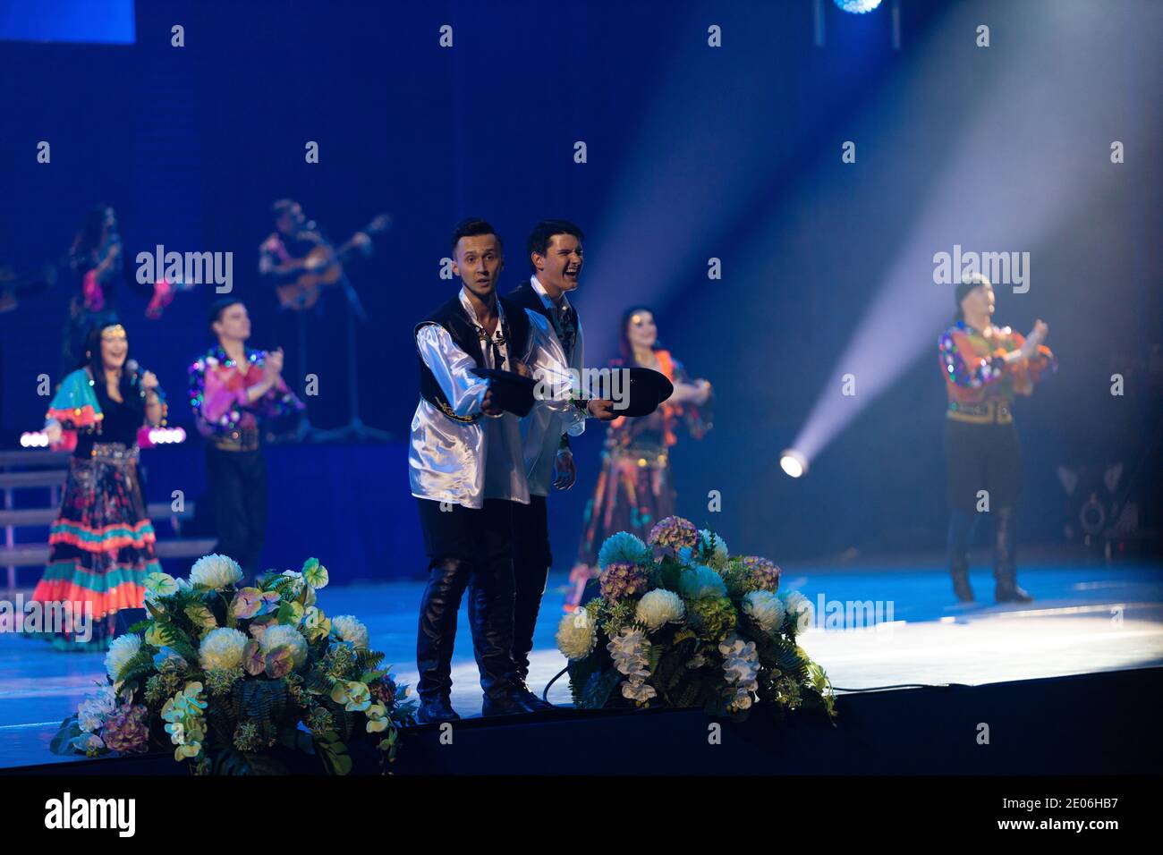 A team of musicians and singers perform on stage in front of the ...