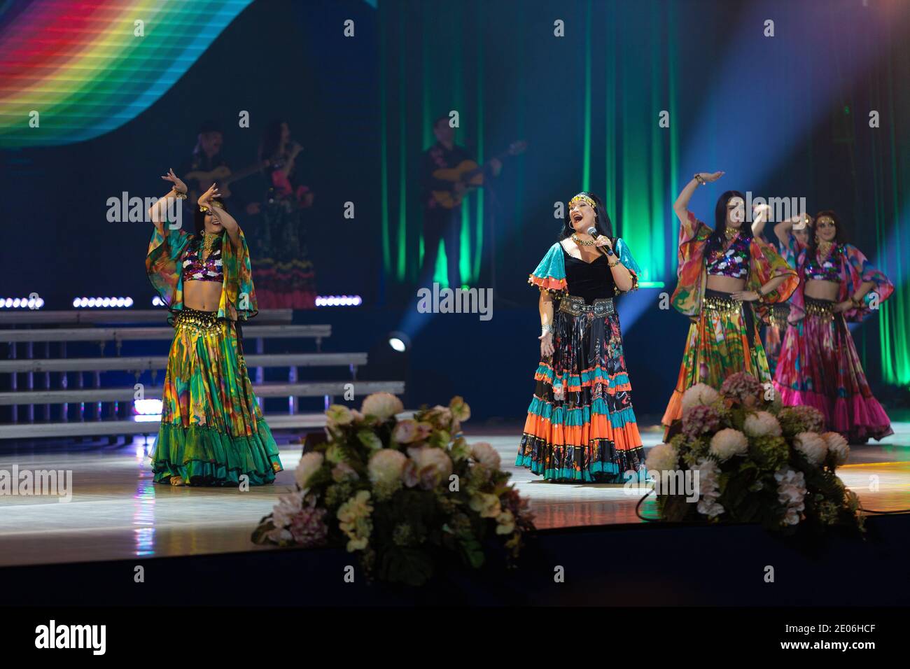 A team of musicians and singers perform on stage in front of the ...