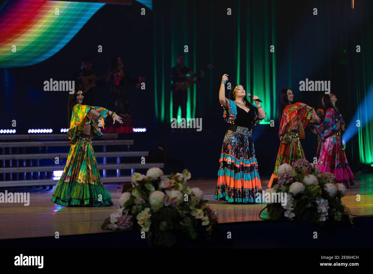 A team of musicians and singers perform on stage in front of the ...