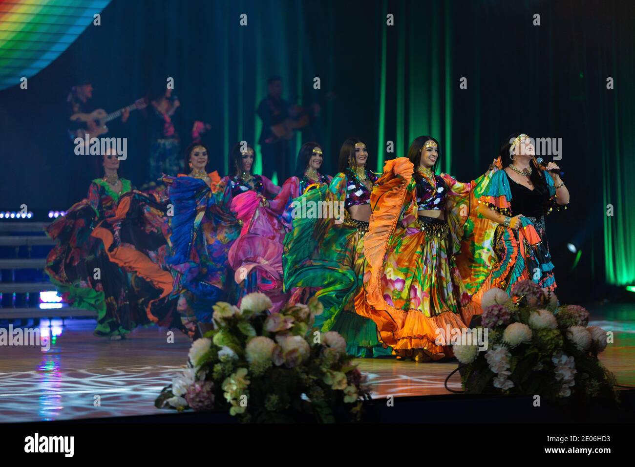 A team of musicians and singers perform on stage in front of the ...