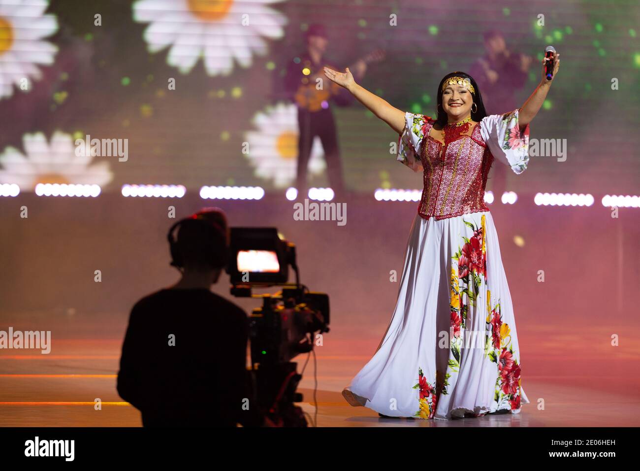 A team of musicians and singers perform on stage in front of the ...