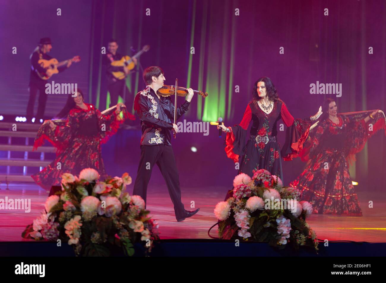 A team of musicians and singers perform on stage in front of the ...