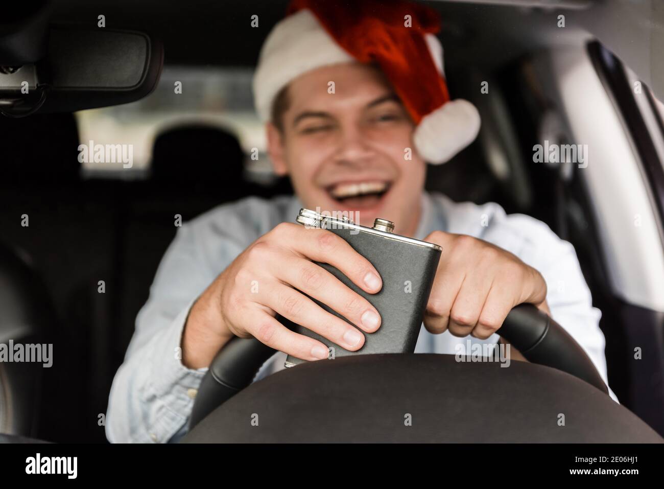 laughing, drunk man in santa hat holding flask with alcohol while ...