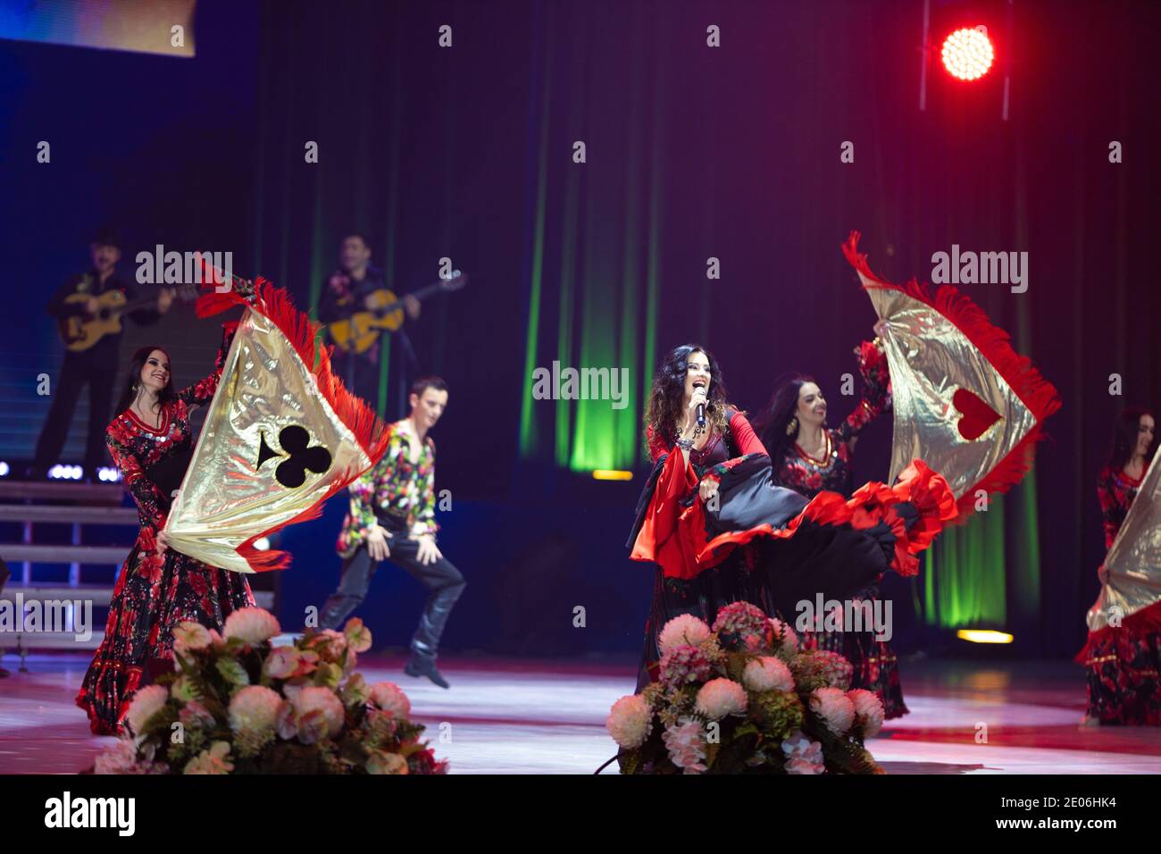 A team of musicians and singers perform on stage in front of the ...