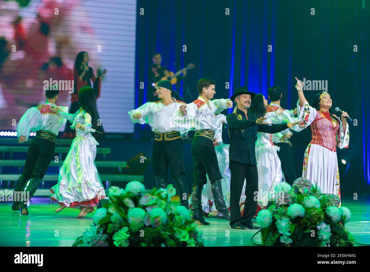 A team of musicians and singers perform on stage in front of the ...