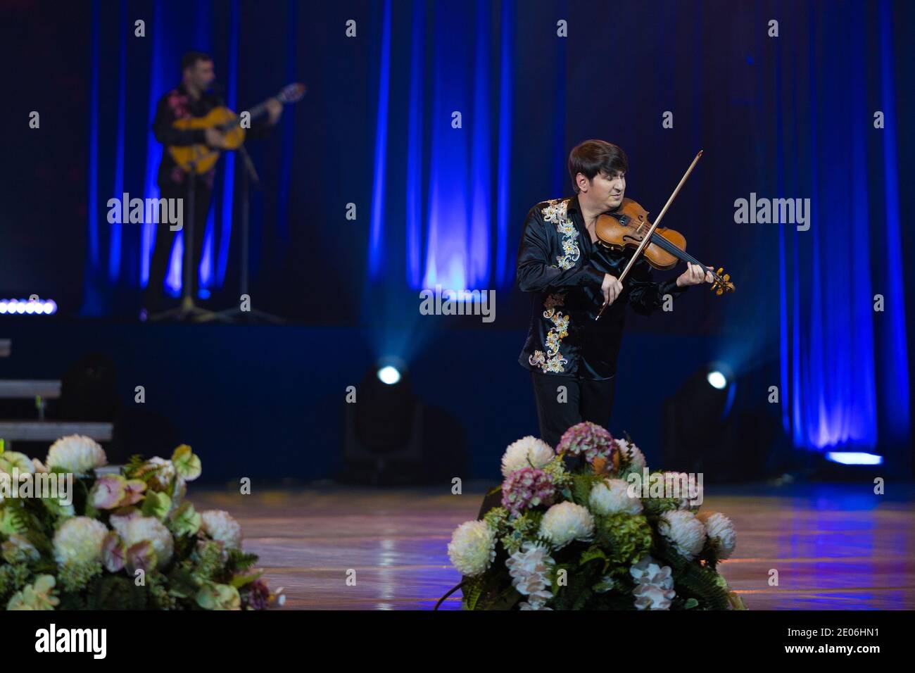 A team of musicians and singers perform on stage in front of the ...