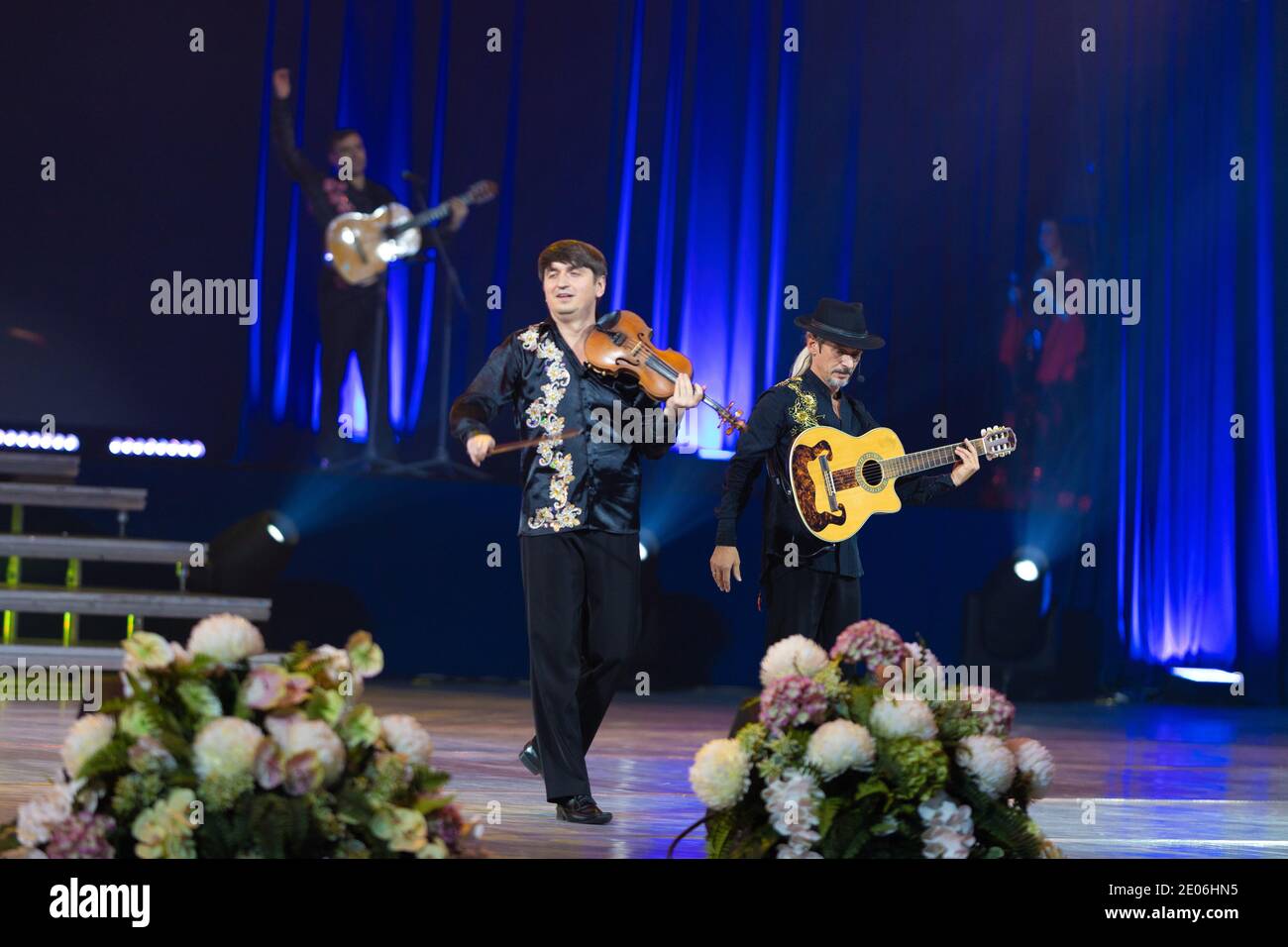 A team of musicians and singers perform on stage in front of the ...