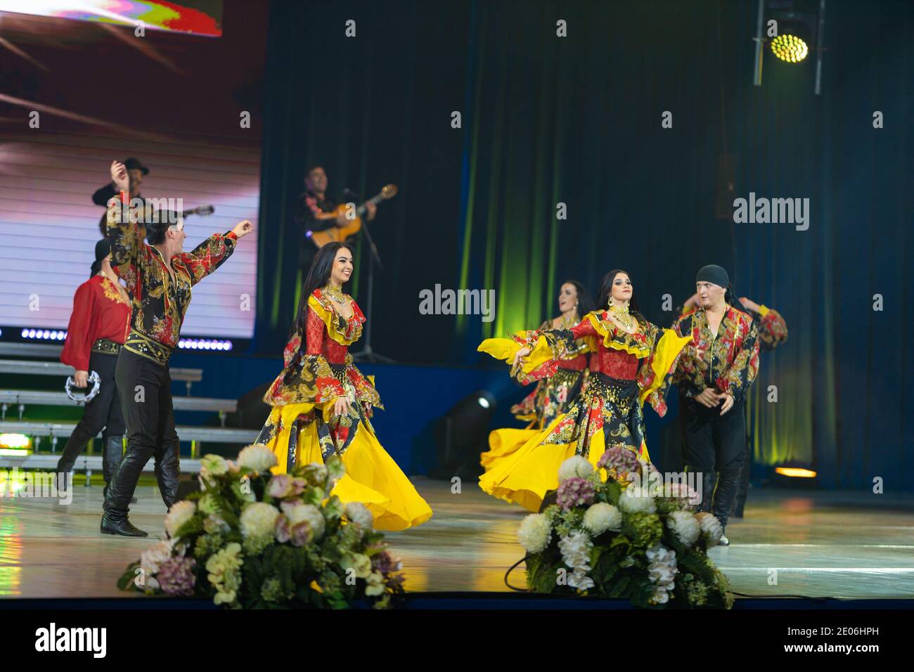 A team of musicians and singers perform on stage in front of the ...