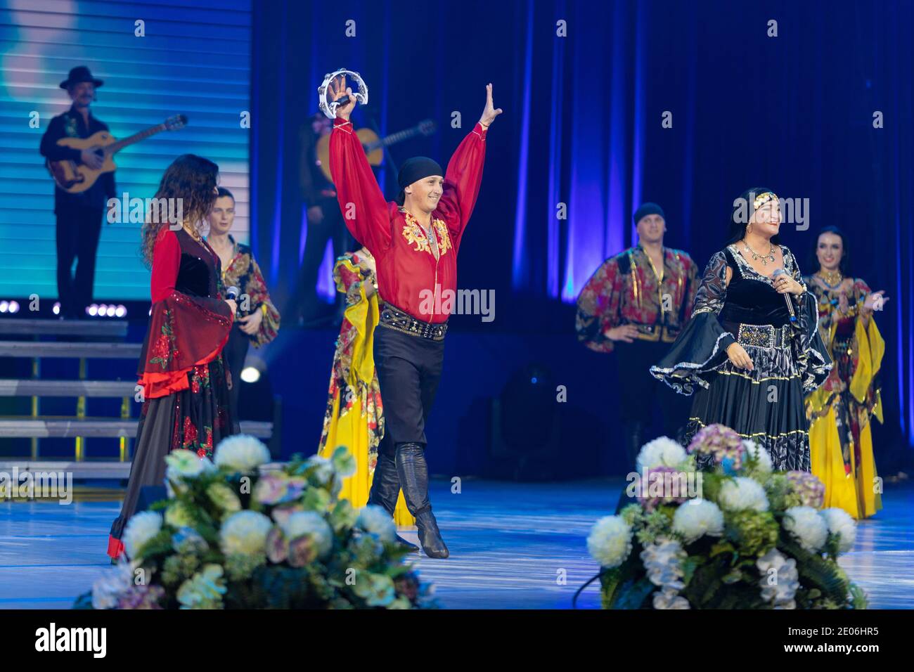 A team of musicians and singers perform on stage in front of the ...